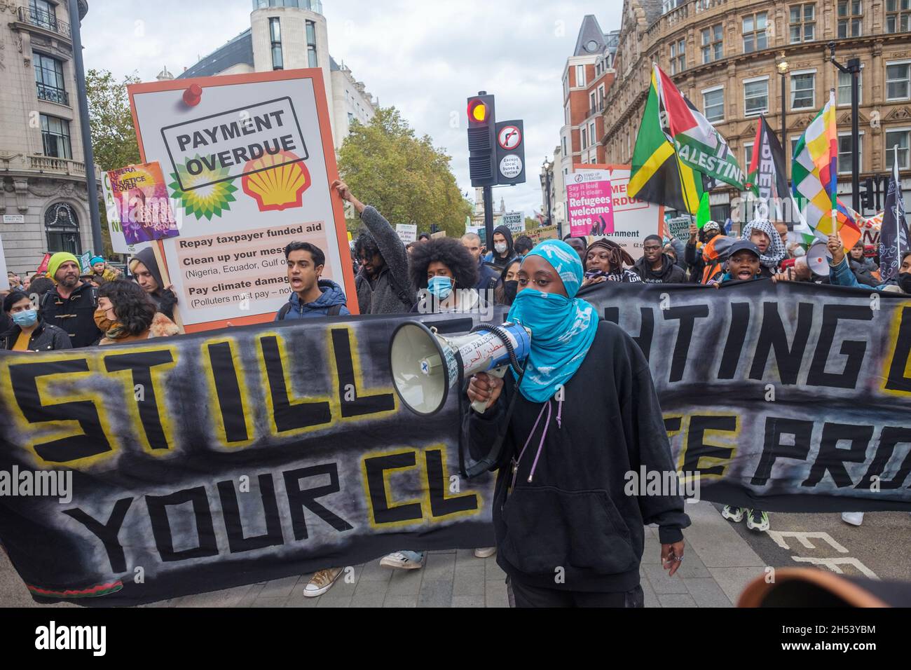 London, UK. 6th Nov 2021. A woman with a megaphone leads the march ...