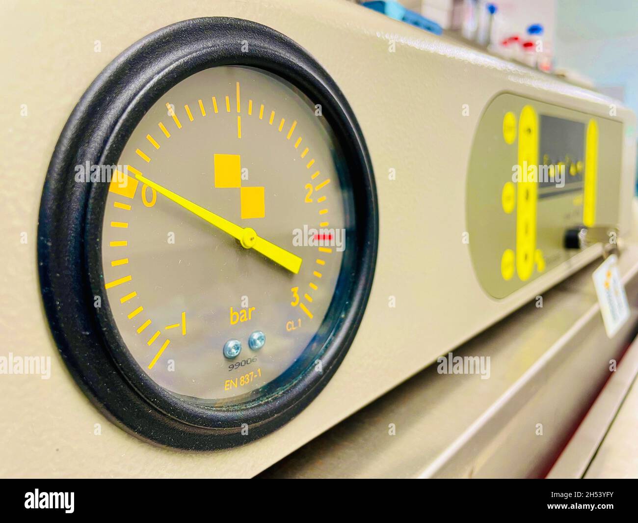 Close-up shot of a scientific pressure gauge instrument with a yellow ...
