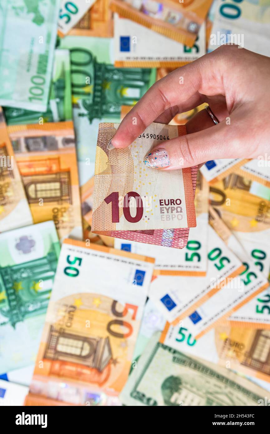 Hand giving euro money isolated on banknotes background Stock Photo - Alamy