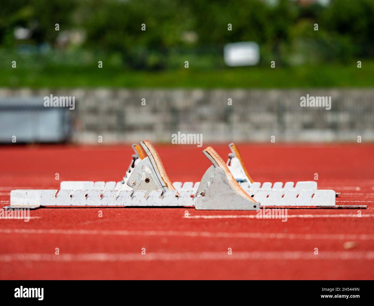 Side view of worn out starting blocks on running tracks. Red running ...