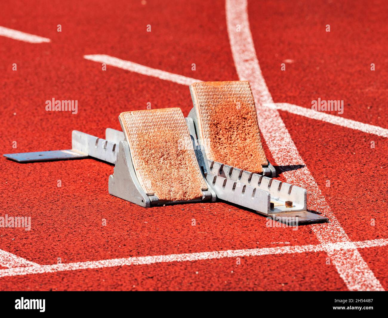 Side view of worn out starting blocks on running tracks. Red running ...