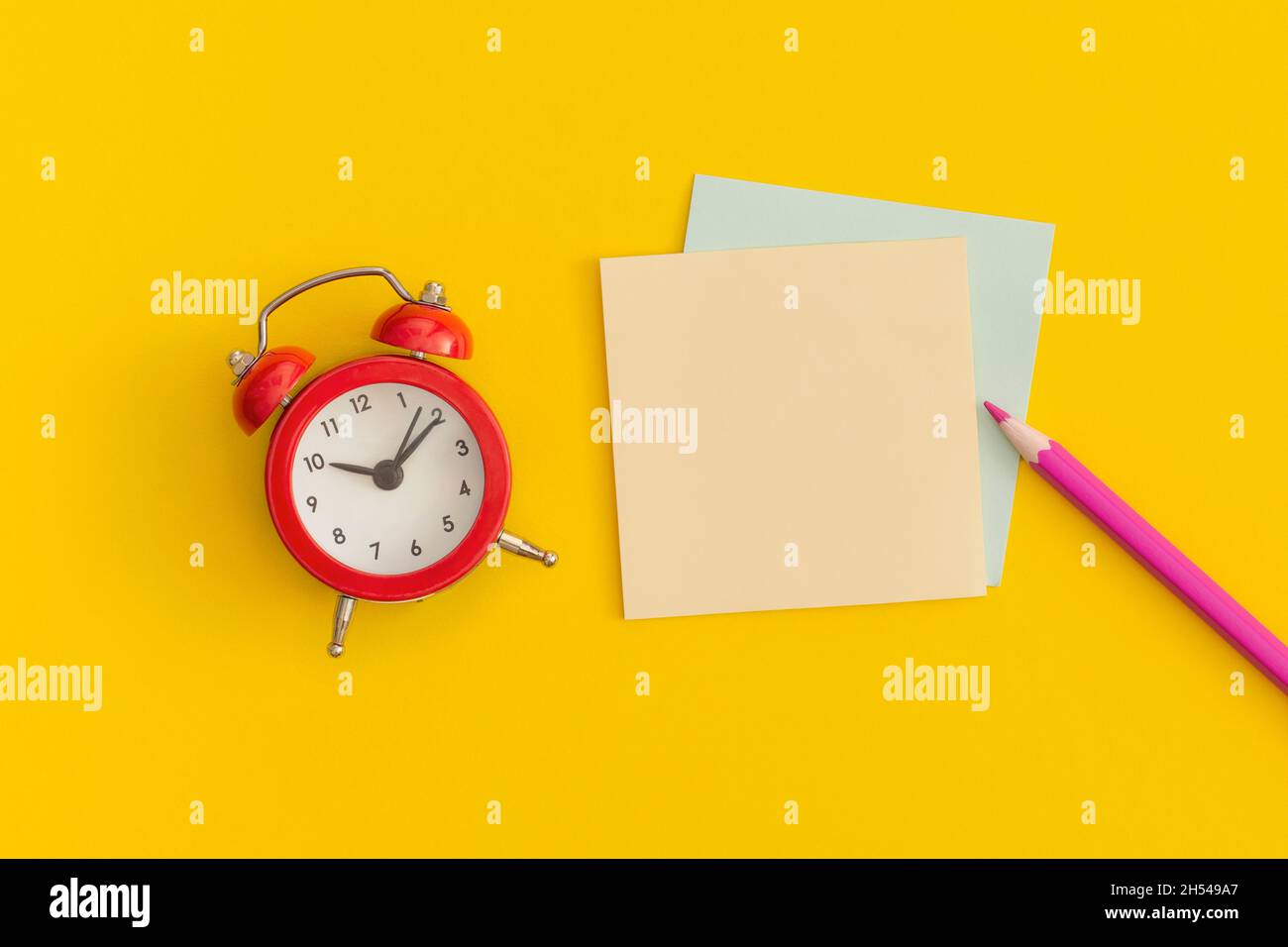 Red alarm clock and sticky notes with space for text on yellow ...