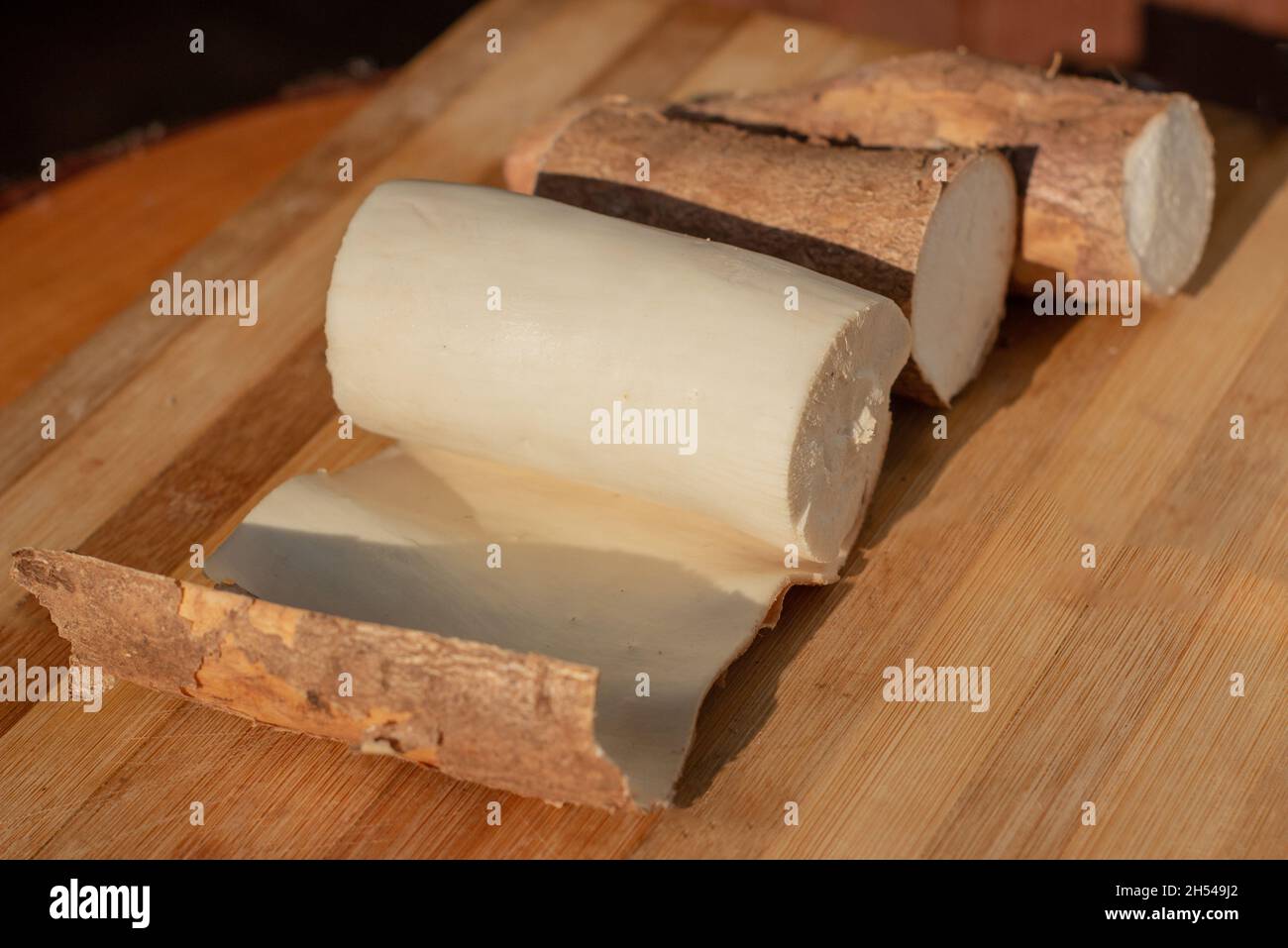 Cassava being peeled on a cooking board Stock Photo - Alamy