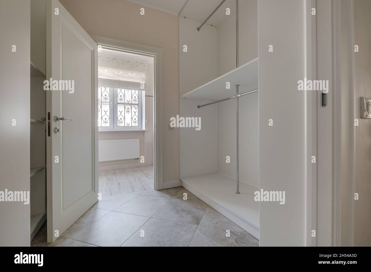 rows of shelves and clothes hangers in empty big wardrobe room in ...