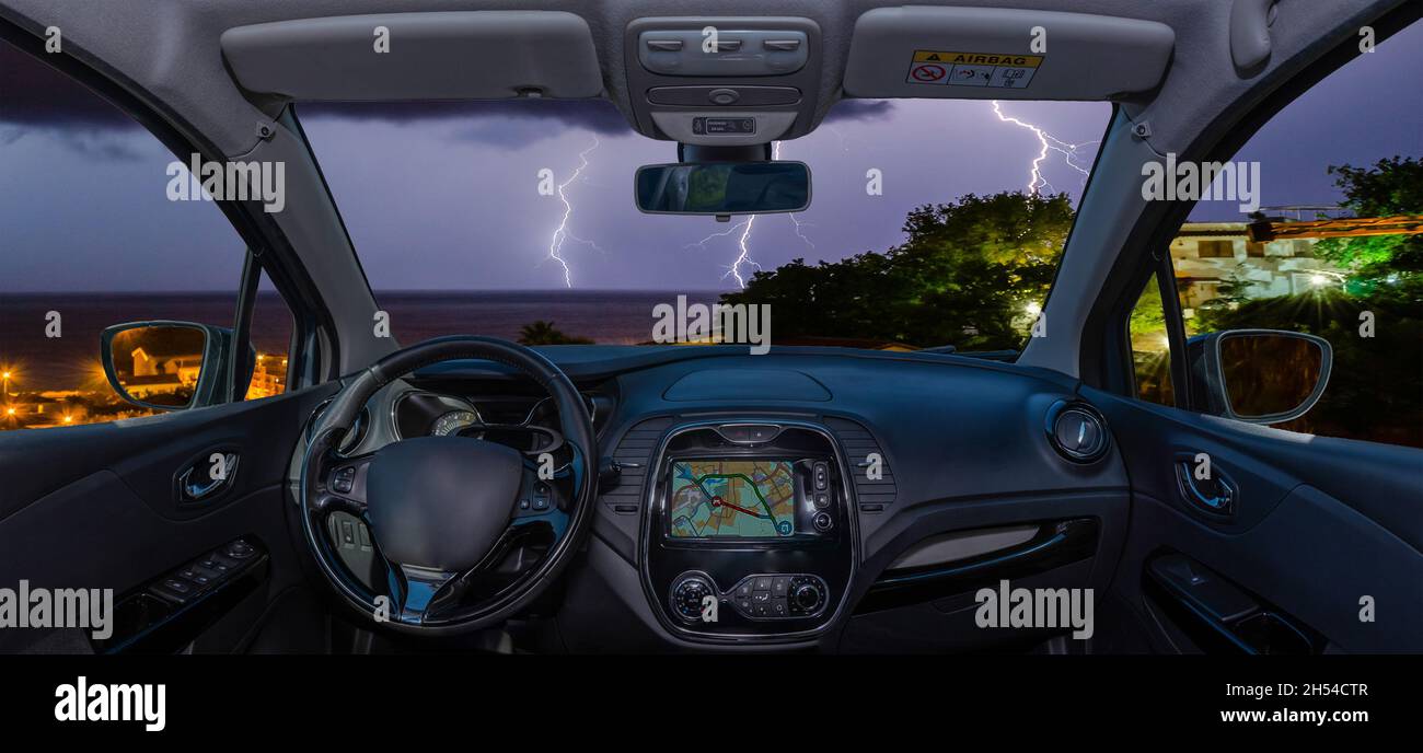 Looking through a car windshield with view over lightning storm over ...