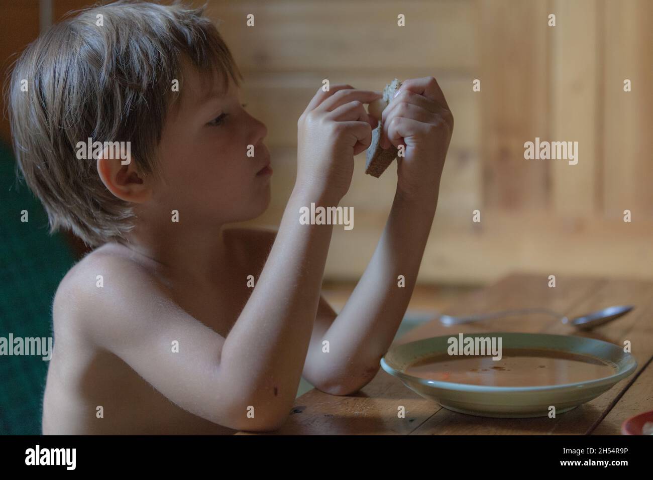 Portrait of small boy child eating soup meal or breakfast having lunch ...