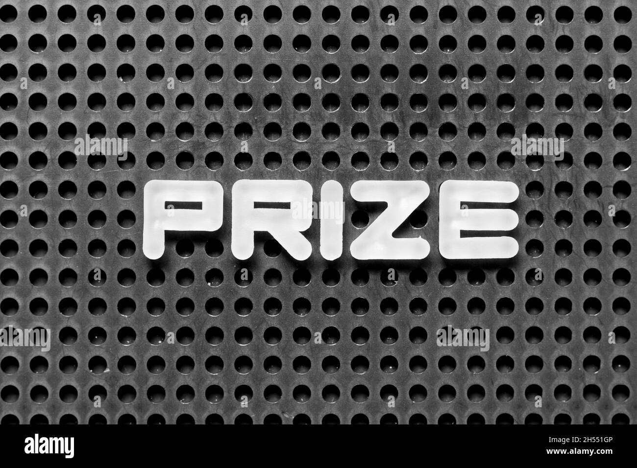 White alphabet letter in word prize on black pegboard background Stock ...