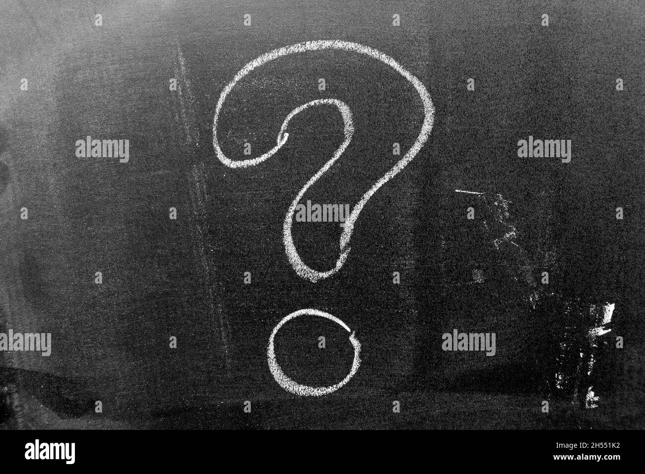 White color chalk hand drawing in in question mark shape on blackboard ...