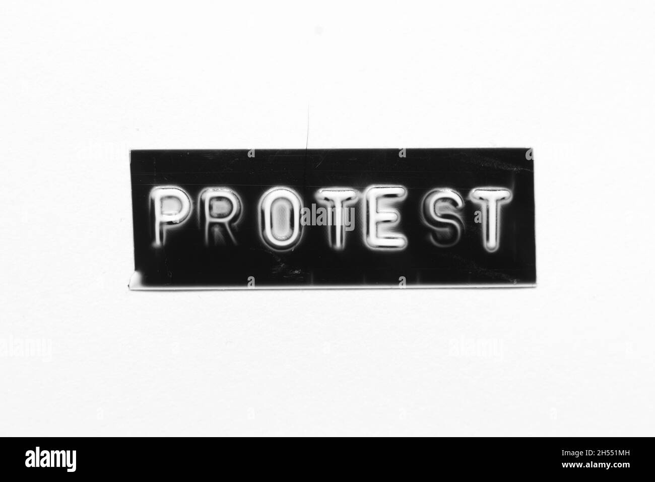 Black color banner that have embossed letter with word protest on white ...