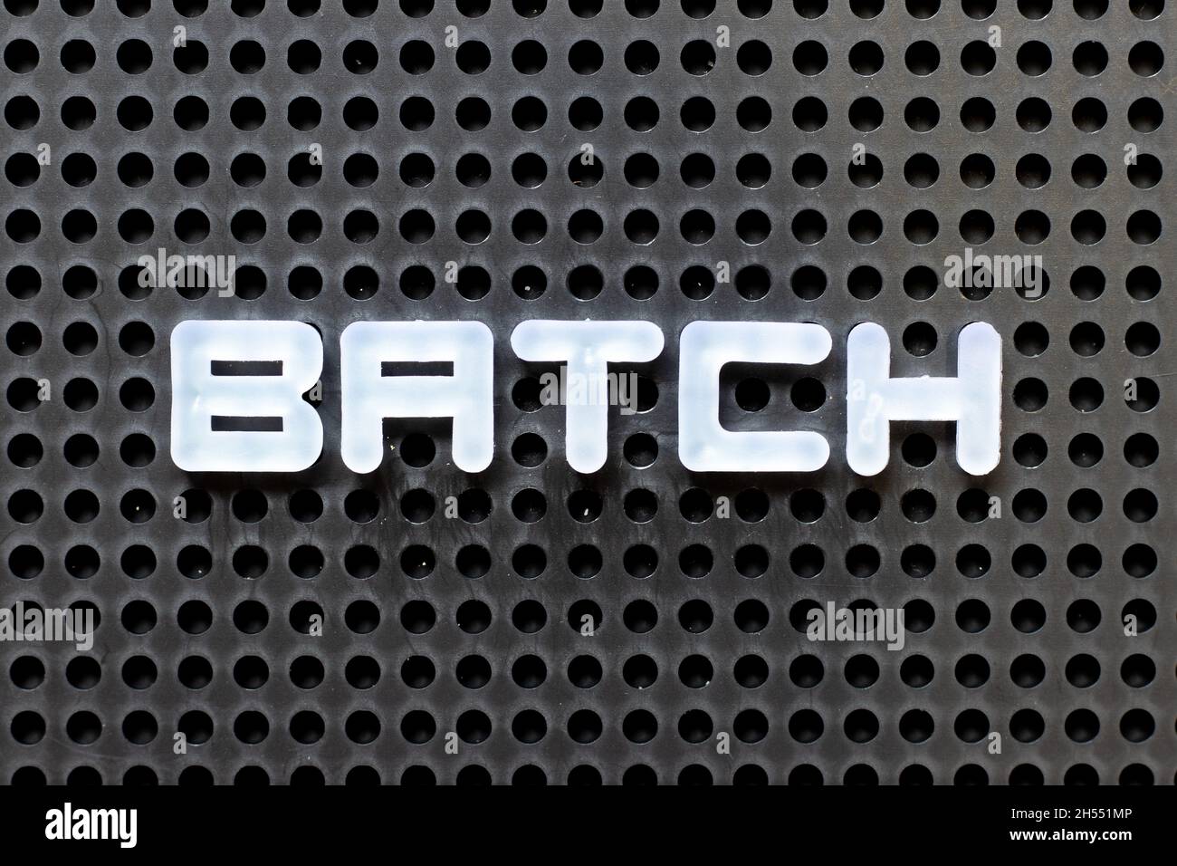 White color alphabet with word batch on black pegboard background Stock ...