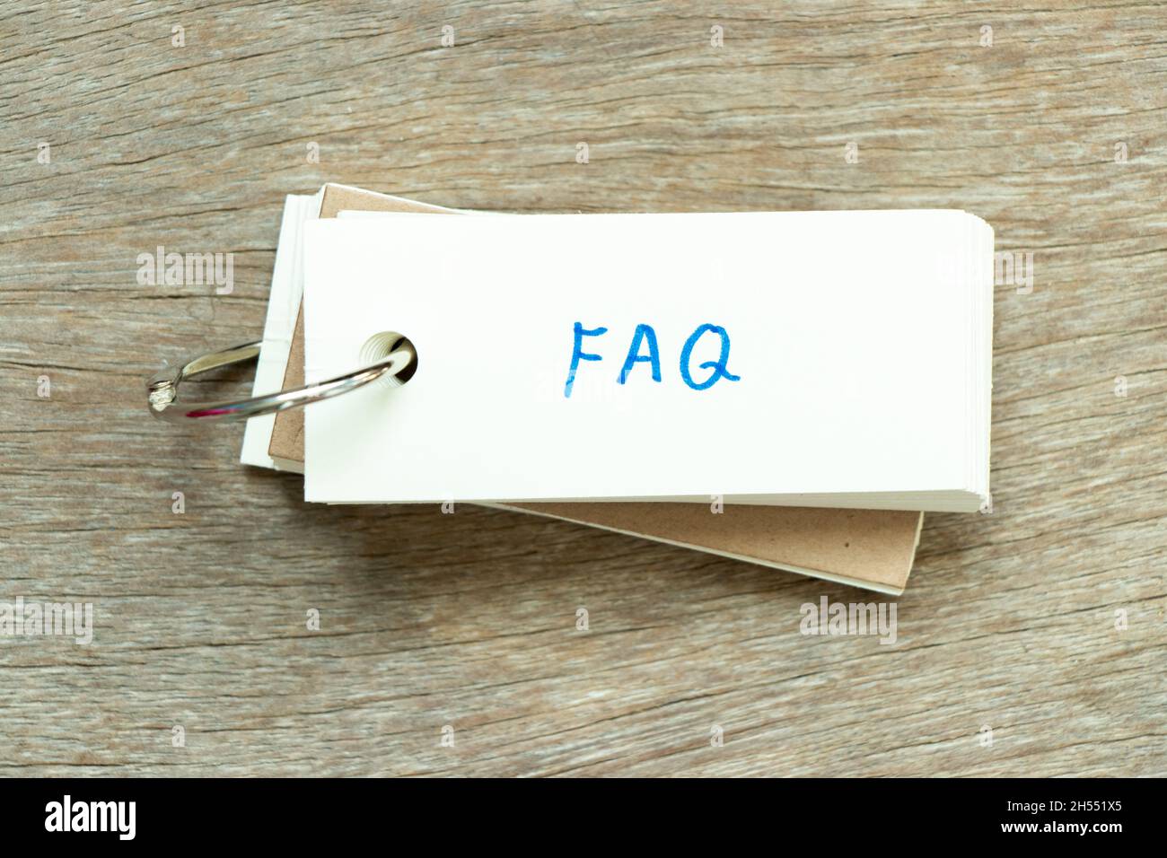 Flash card with handwriting word FAQ (Abbreviation of Frequently asked ...