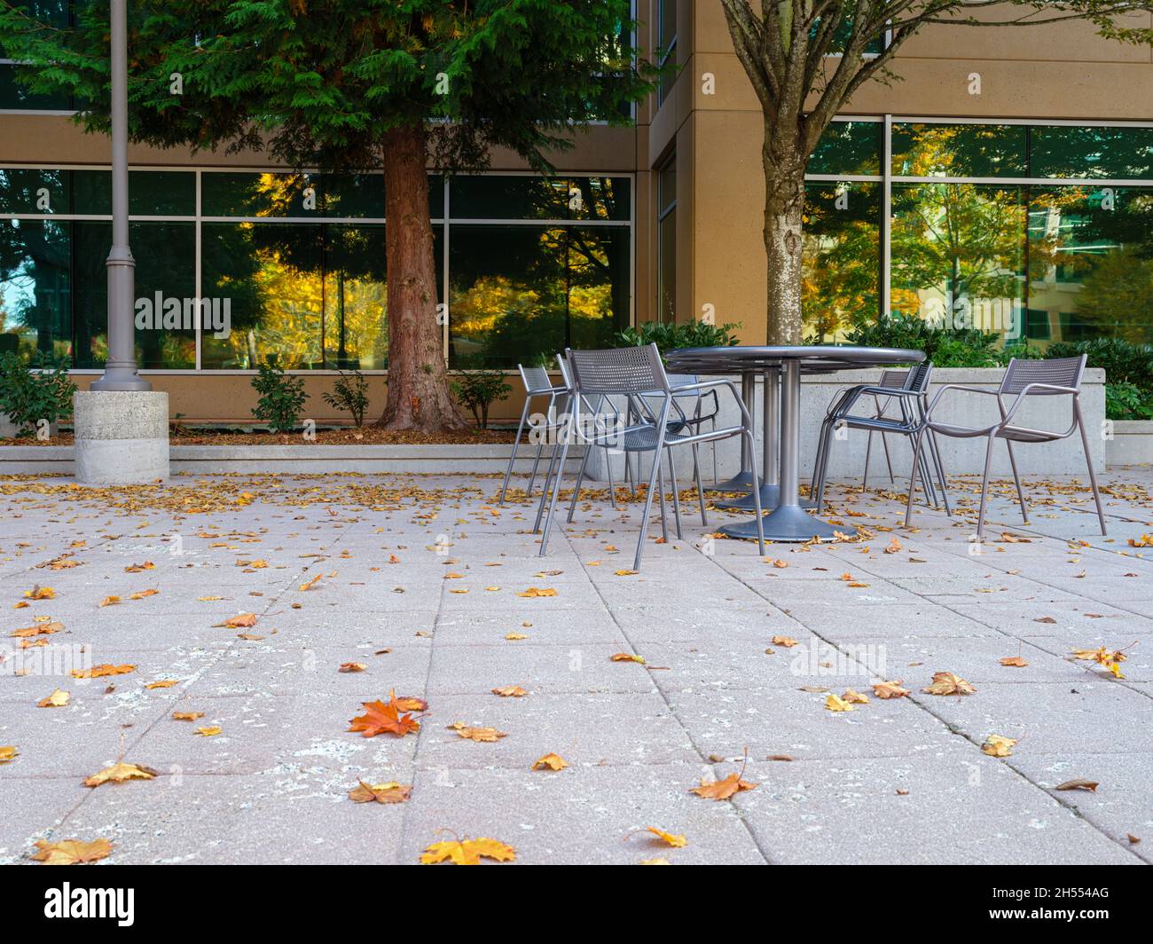 Metal table and chairs outside an office building in the autumn Stock ...