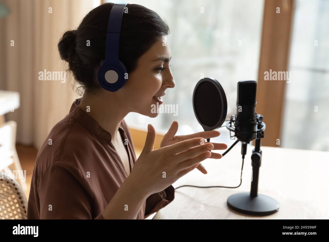 Female podcaster making audio podcast for internet audience, closeup ...