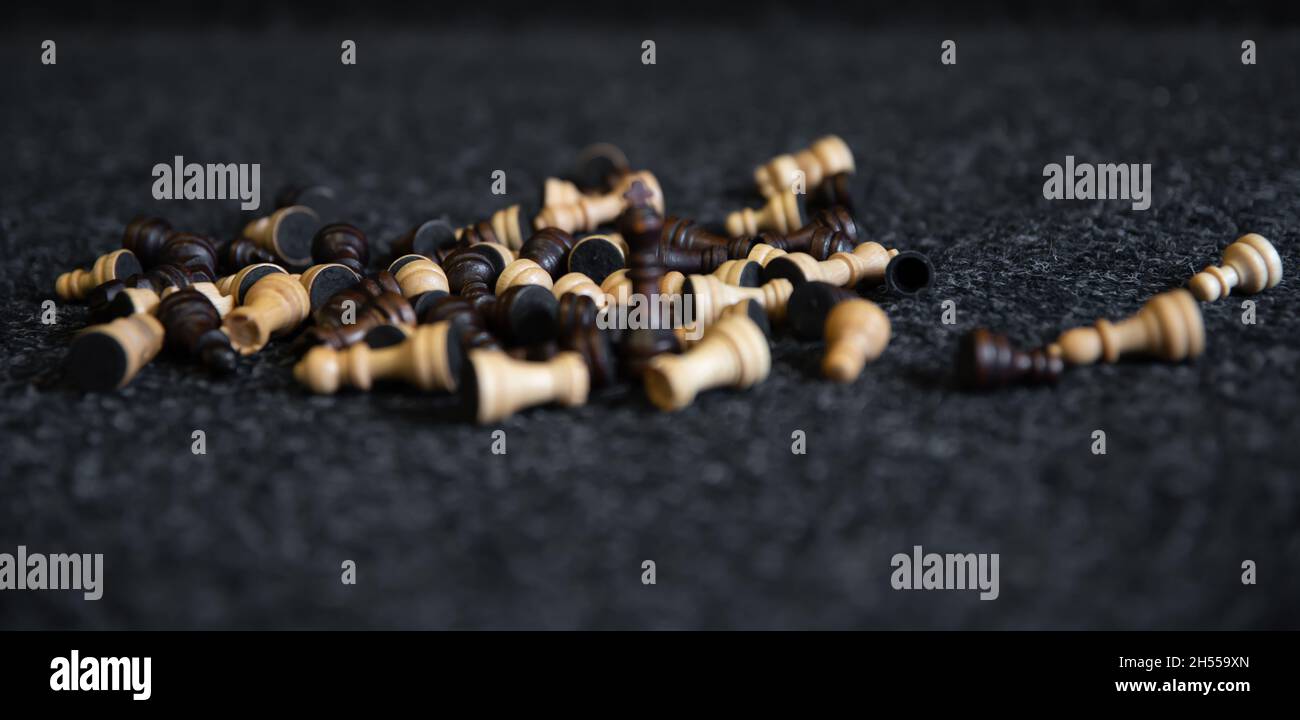 Scattered chess pieces on a blurred black background Stock Photo - Alamy