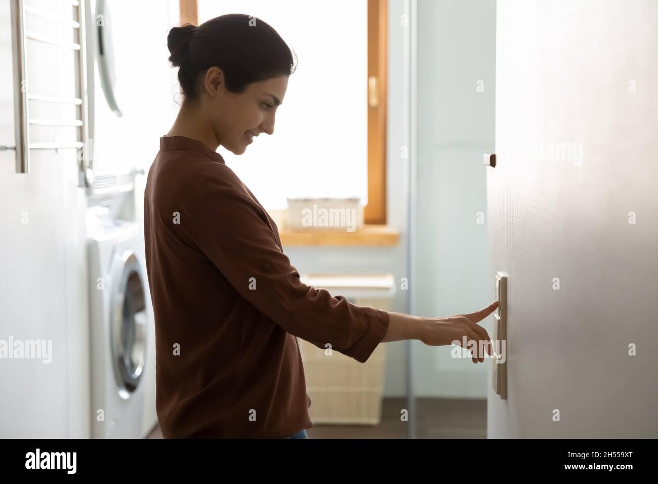 Indian female push button turns on light inside laundry room Stock ...