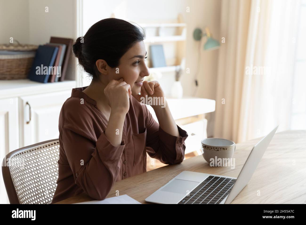Distracted from computer work Indian female looking at distance Stock ...