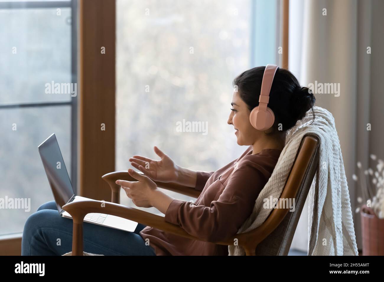 Indian woman wear headphones use laptop talk via video conference Stock ...