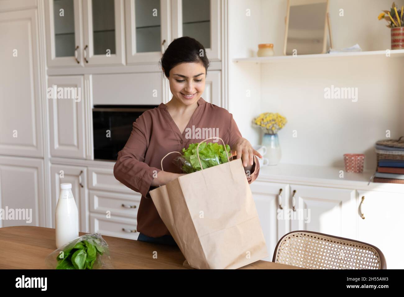Indian woman unpack shopping bag with fresh quality groceries products ...