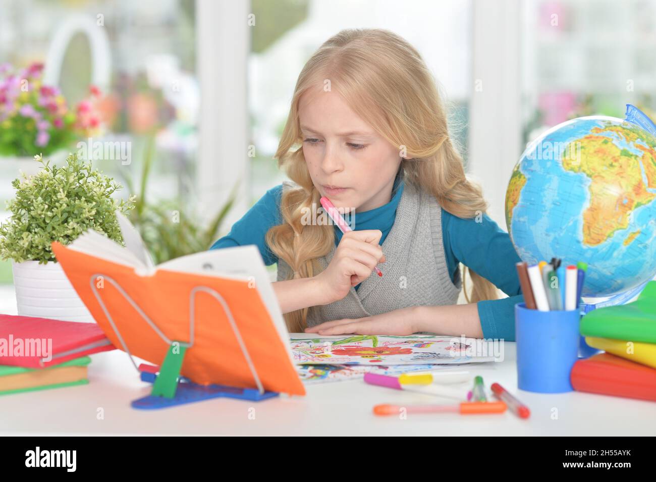 Portrait of cute little girl studying at home Stock Photo - Alamy