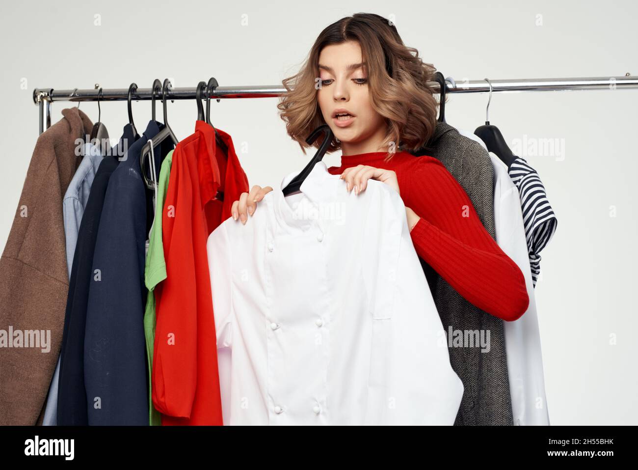 pretty woman with glasses selection of clothes near the wardrobe ...