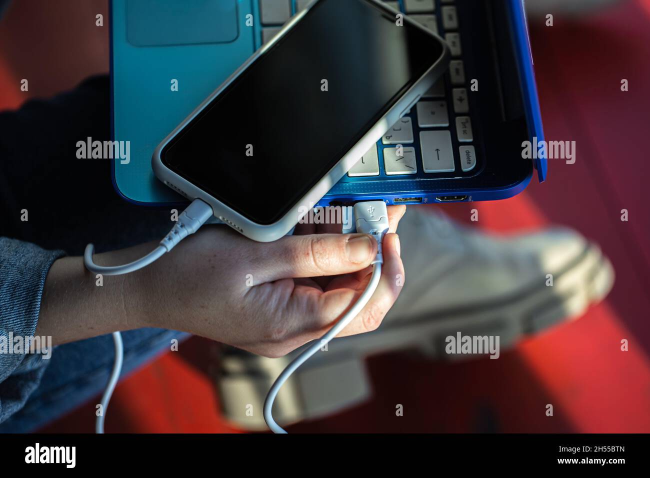 The smartphone is connected to the laptop via USB cable Stock Photo - Alamy