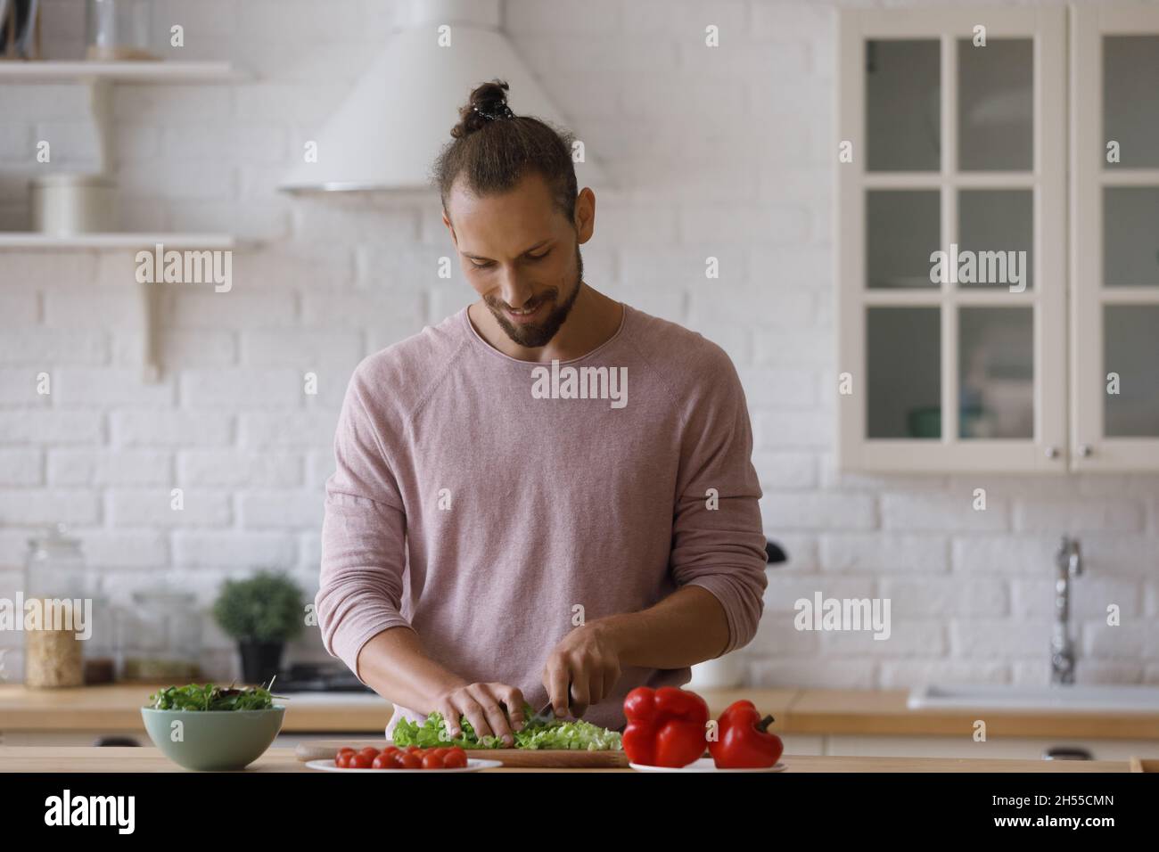 Smiling handsome young man cooking alone in kitchen Stock Photo - Alamy