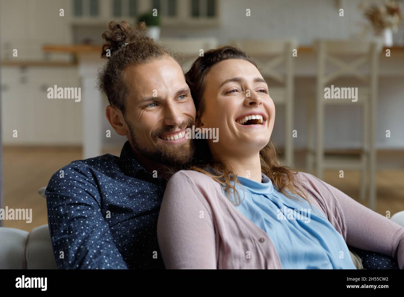 Happy affectionate young family couple watching TV programs Stock Photo ...