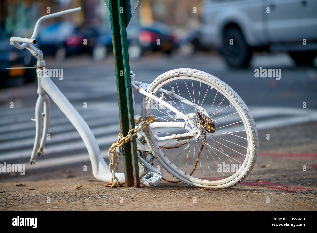 Abandoned white bike in New York City. Bicycle without a wheel locked ...