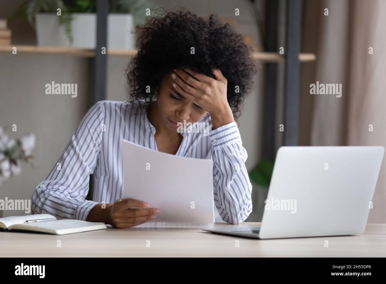 Unhappy African American woman reading bad news in letter Stock Photo ...