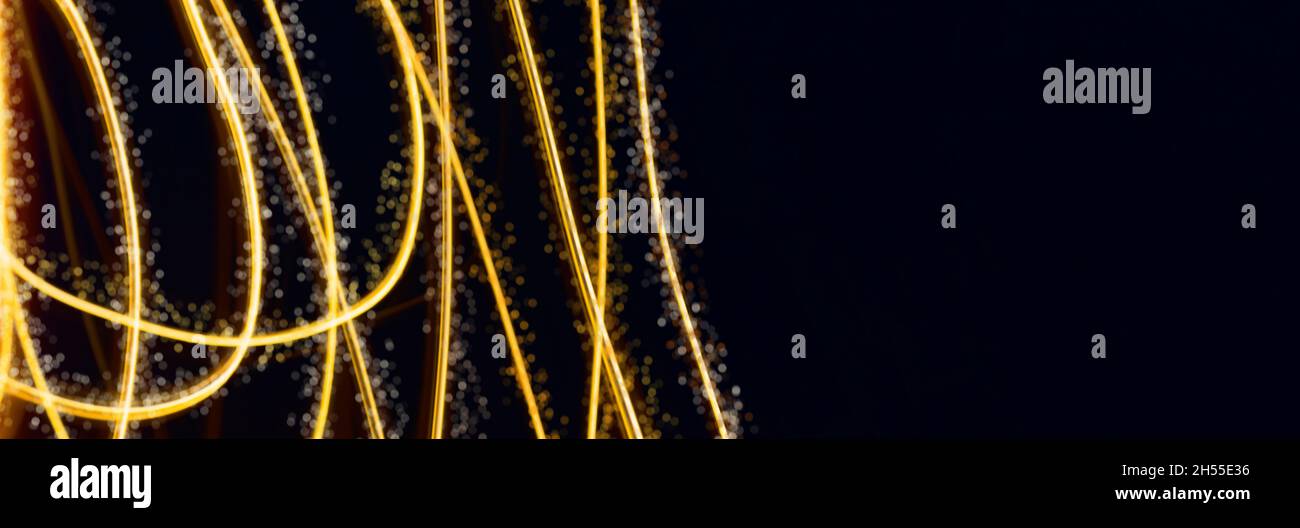 Gold neon festive lines on black background Stock Photo - Alamy