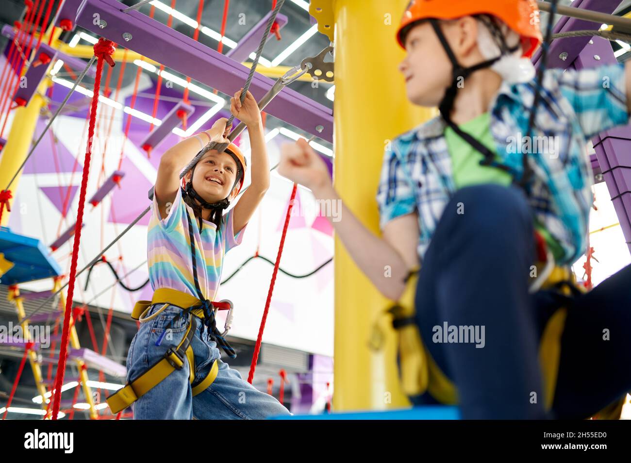 Happy children on zip line in entertainment center Stock Photo - Alamy