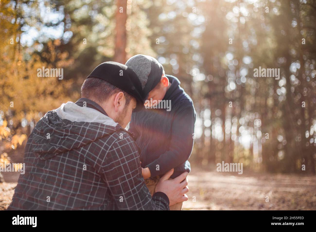 Father`s day. Sad son hugging dad on the forest background with copy ...