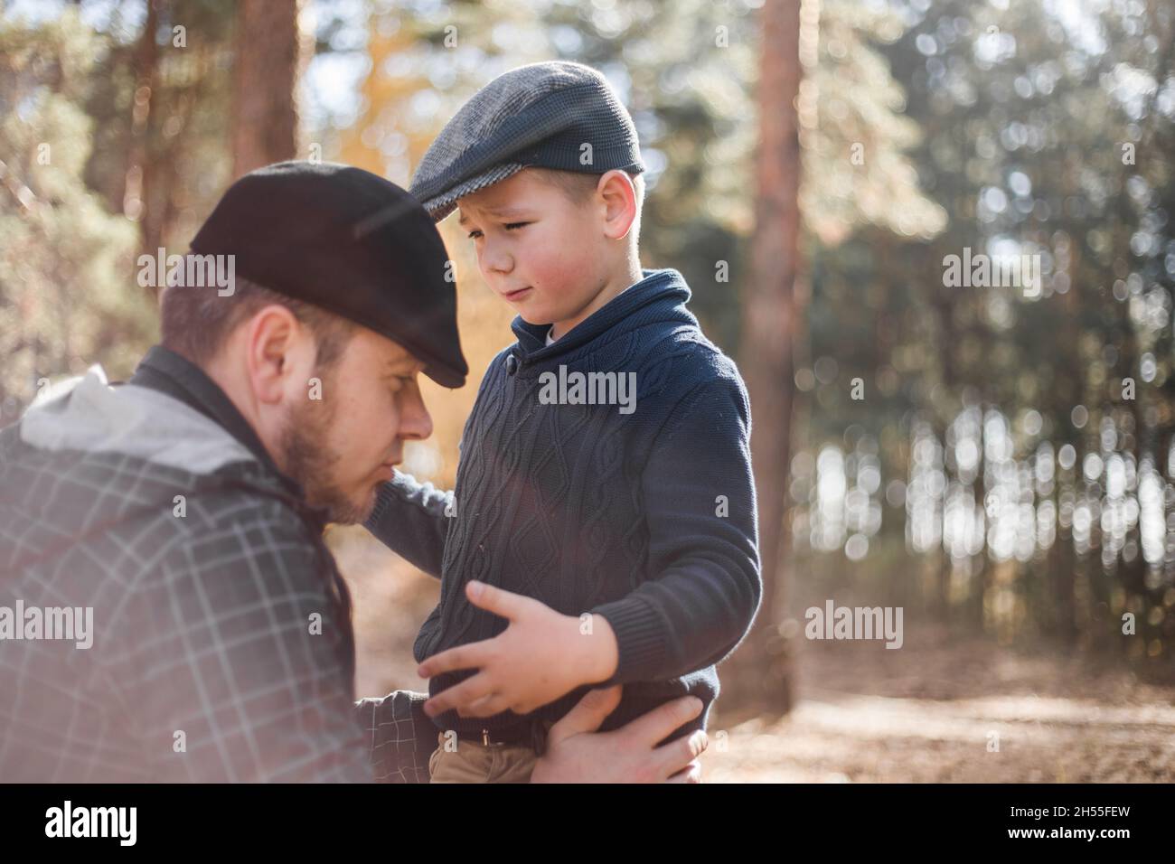 Father`s day. Sad son hugging dad on the forest background with copy ...