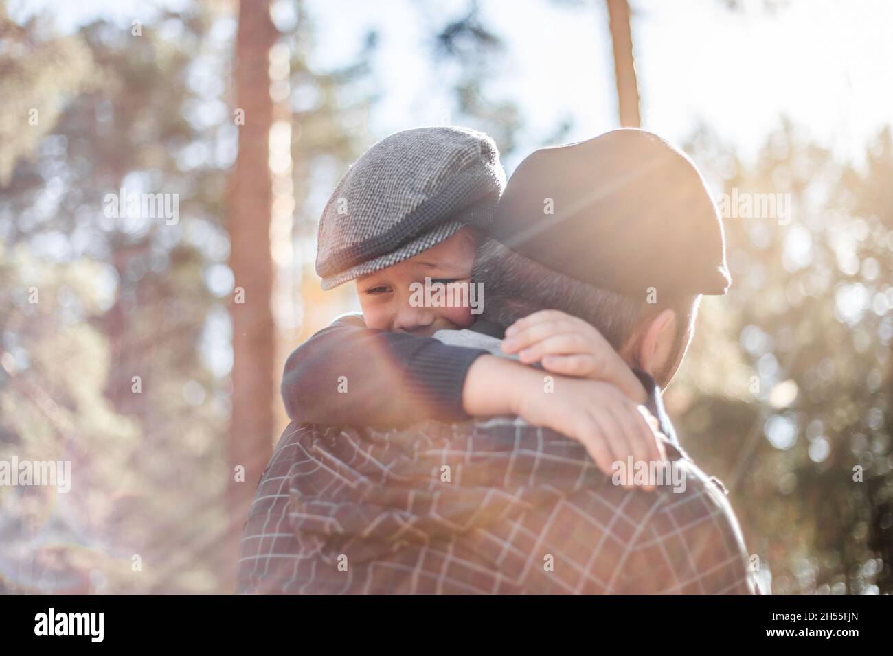 Father`s day. Sad son hugging dad on the forest background with copy ...