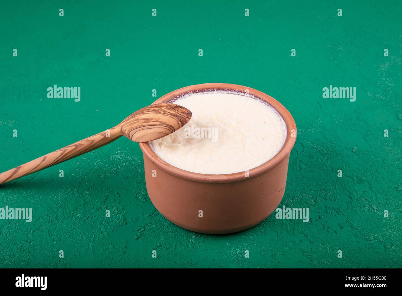 Natural,yogurt in casserole bowl on wooden table with spoon.Close up ...