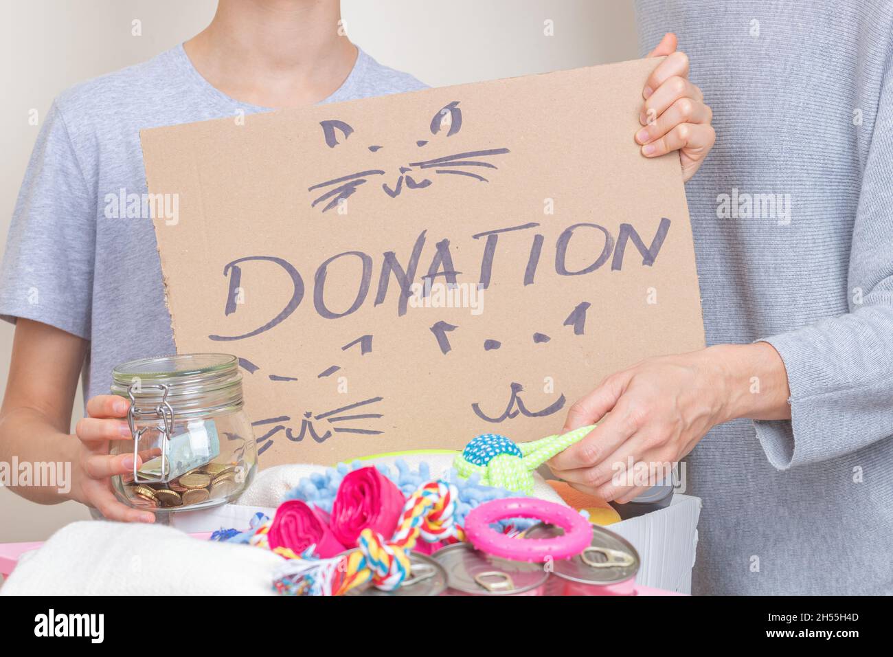Kid and woman hands holding brown piece of cardboard with inscription ...