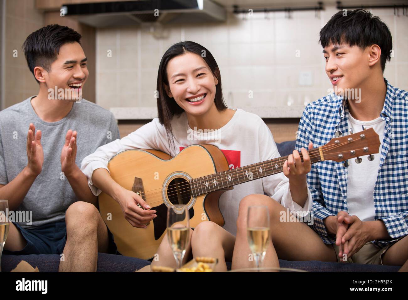 Happy young people playing guitar at home Stock Photo - Alamy
