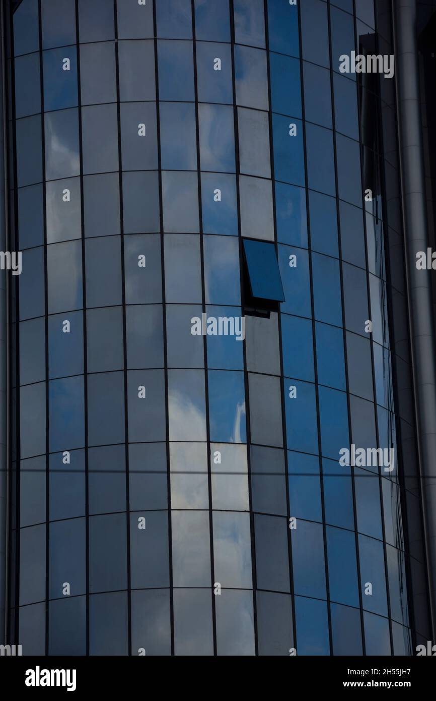 One open window in a glass building reflecting sky and clouds Stock ...