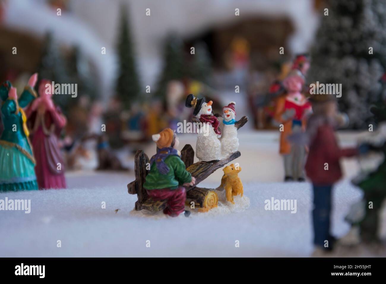 Children playing with snowmen at playground in a small winter Christmas ...