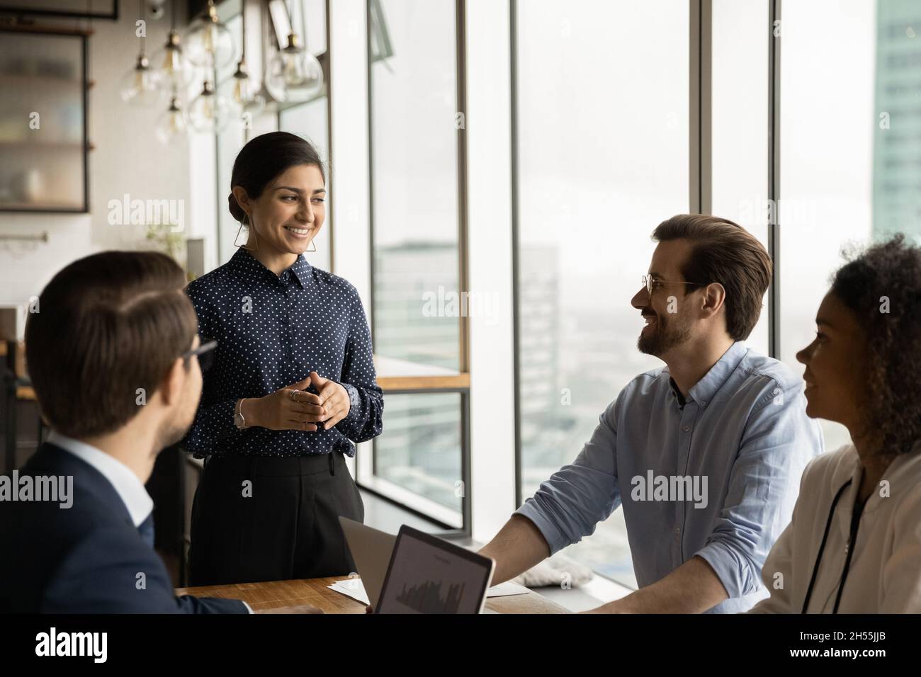 Happy indian team leader holding meeting with diverse colleagues Stock ...