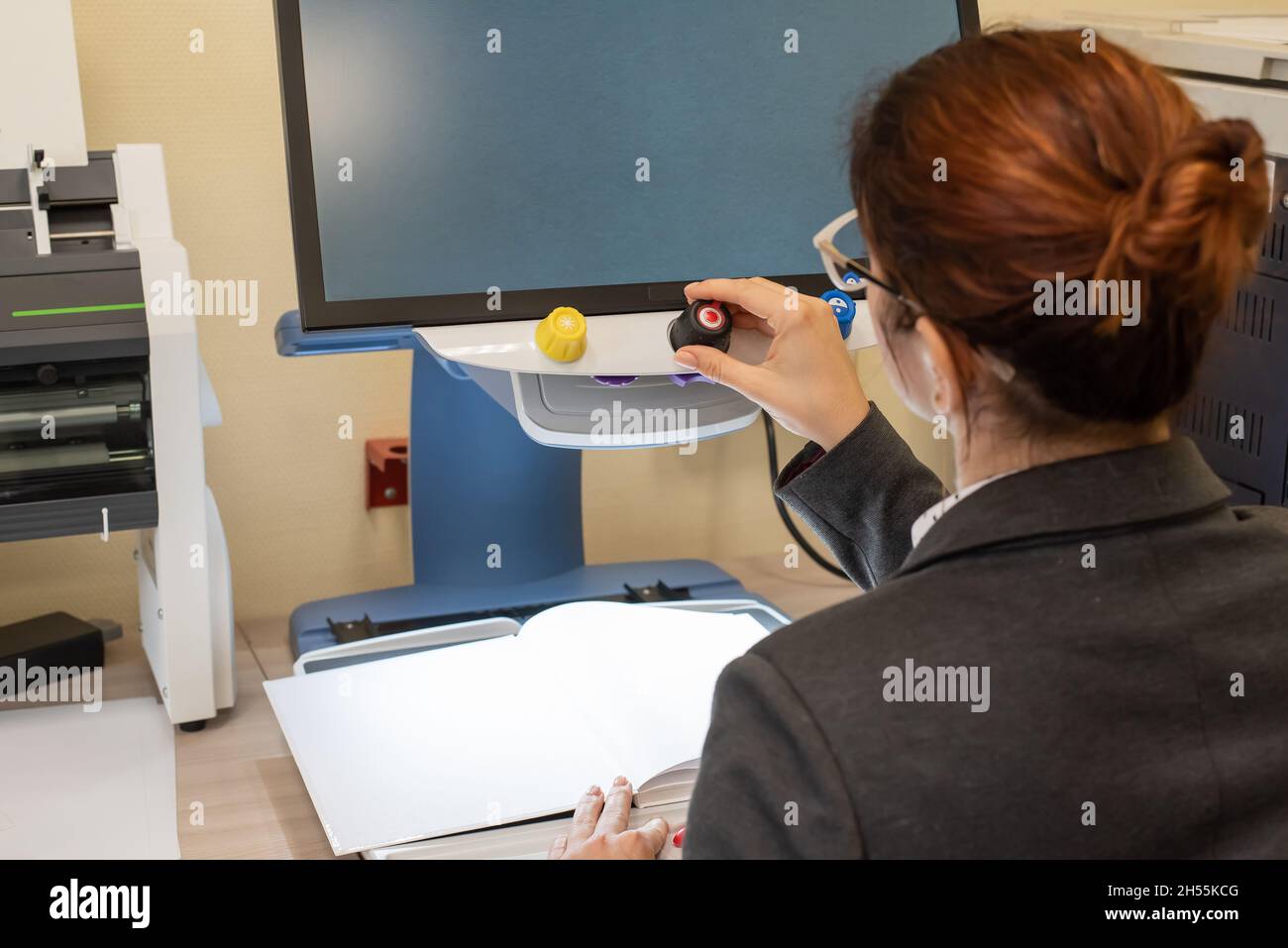 A visually impaired woman uses special reading equipment Stock Photo ...