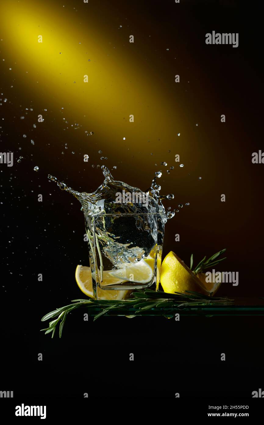 Gin and tonic cocktail with lemon slices and rosemary sprigs. A slice ...