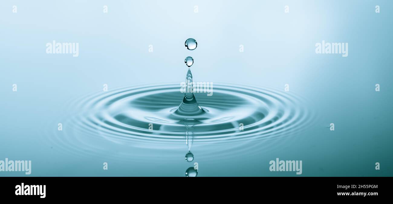 Splash of water droplets on a smooth water surface Stock Photo - Alamy