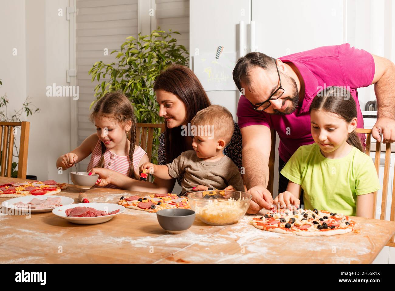 the young parents are cooking with their children Stock Photo - Alamy