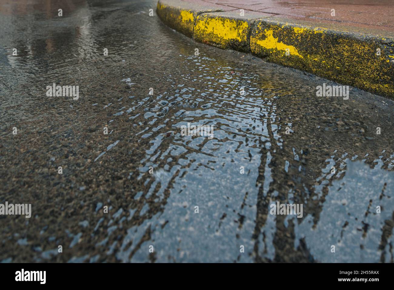 Water is flowing on a road in a small city Stock Photo - Alamy