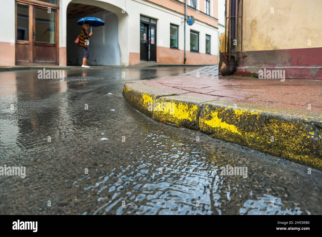 Water is flowing on a road in a small city Stock Photo - Alamy