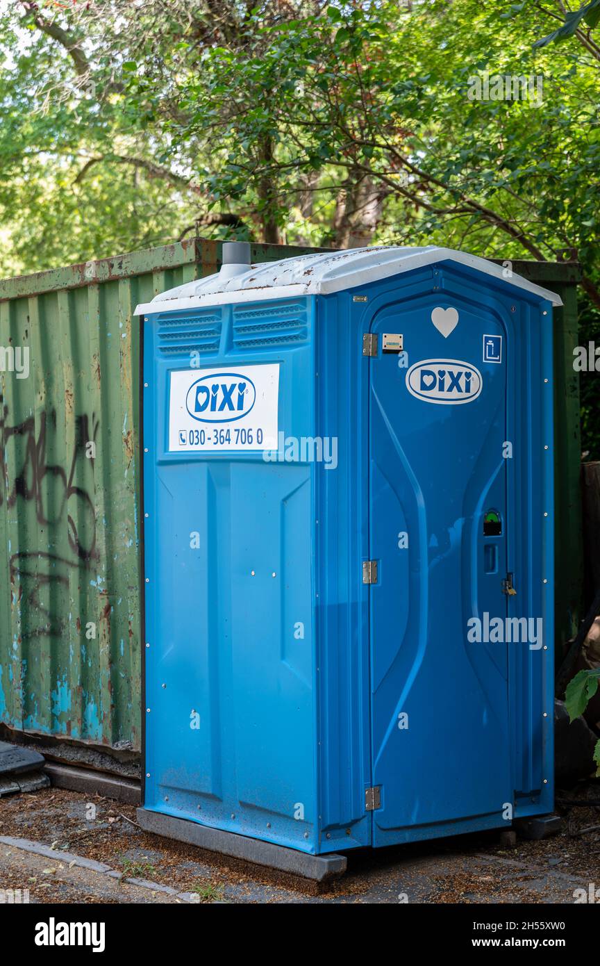 A Dixi rental toilet on the construction site next to a container Stock ...