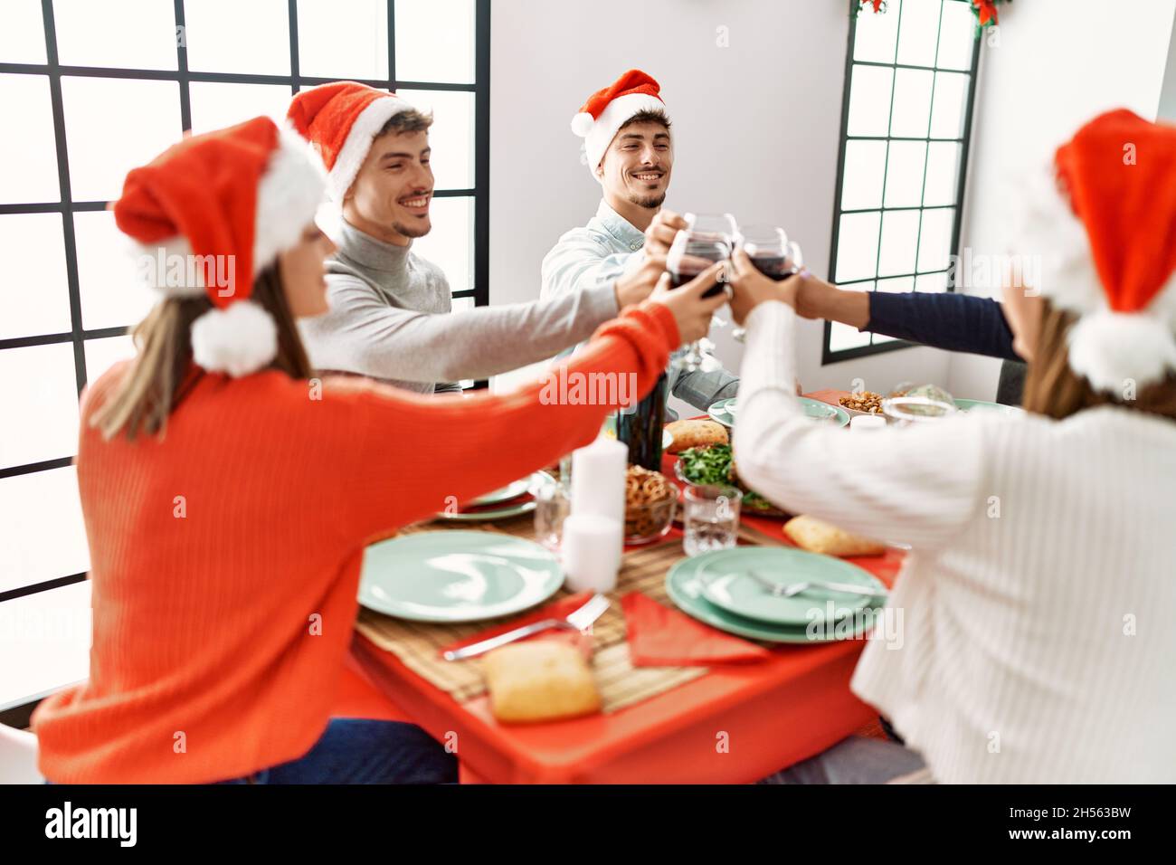 Group of young people smiling happy celebrating christmas toasting with ...