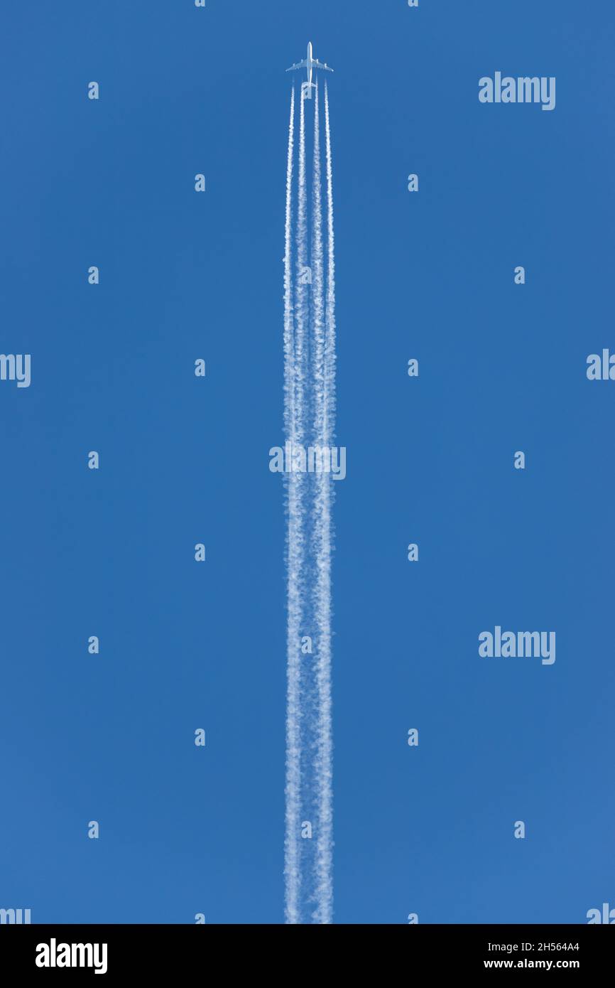 engine exhaust contrails behind an four-engined commercial aircraft ...