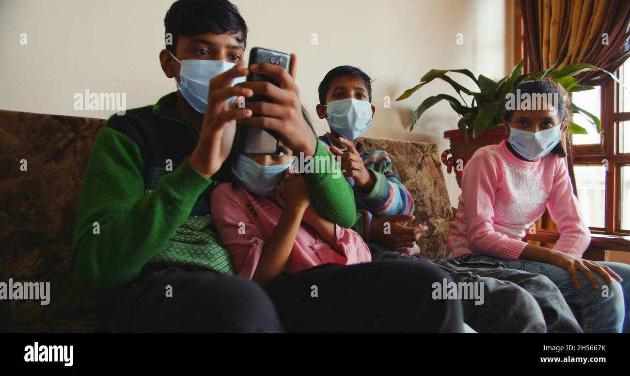 Cute children with masks playing at home Stock Photo - Alamy